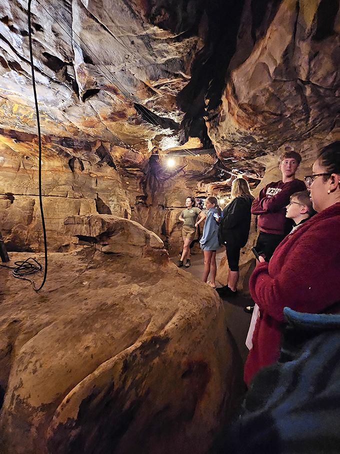 Wide-eyed visitors absorb the guide's tales of geological wonders, each face illuminated by the same awe that humans have felt here for generations.