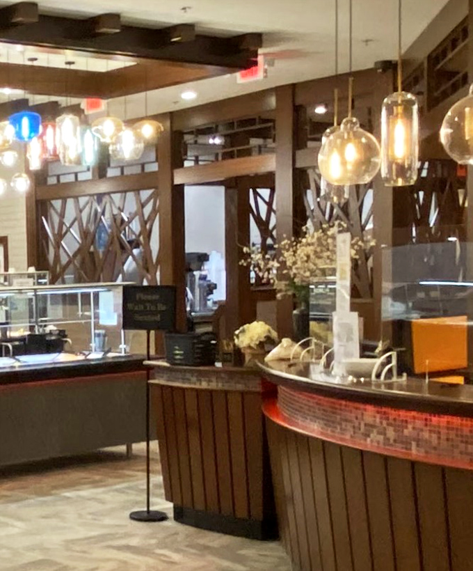 The hostess stand: your gateway to gluttony, where pendant lights dangle like jewelry above the promise of culinary adventure.