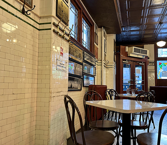 Classic marble-topped tables and wire-backed chairs create an atmosphere where time slows down and conversations flow as freely as the drinks.