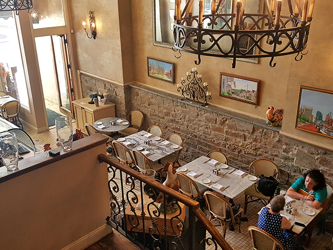 A multi-level dining room that feels both intimate and grand. Those wrought-iron details and warm lighting? Pure bistro romance.