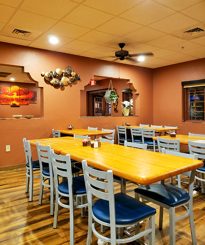 Warm wood tones and terracotta walls create a dining room that feels like coming home. Those blue chairs aren't just seating—they're front-row tickets to flavor country.