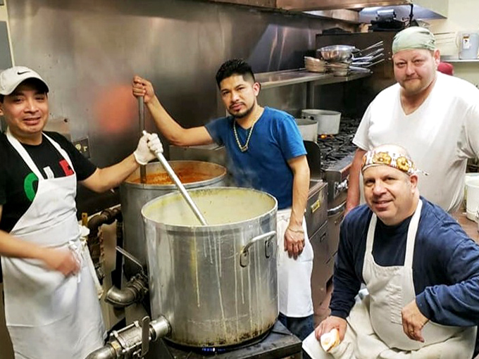 Where the magic happens &ndash; the kitchen crew tending to massive pots of sauce that have likely been simmering since before you woke up.