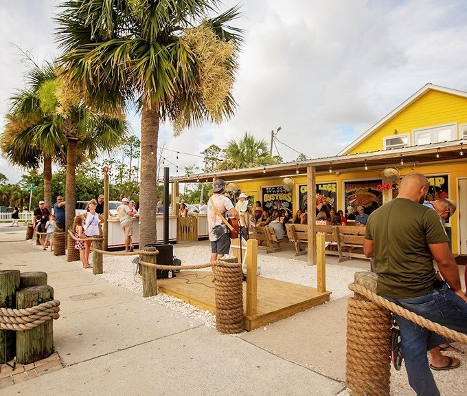 The outdoor seating area where waiting becomes part of the experience. Those wooden benches have supported generations of seafood enthusiasts.