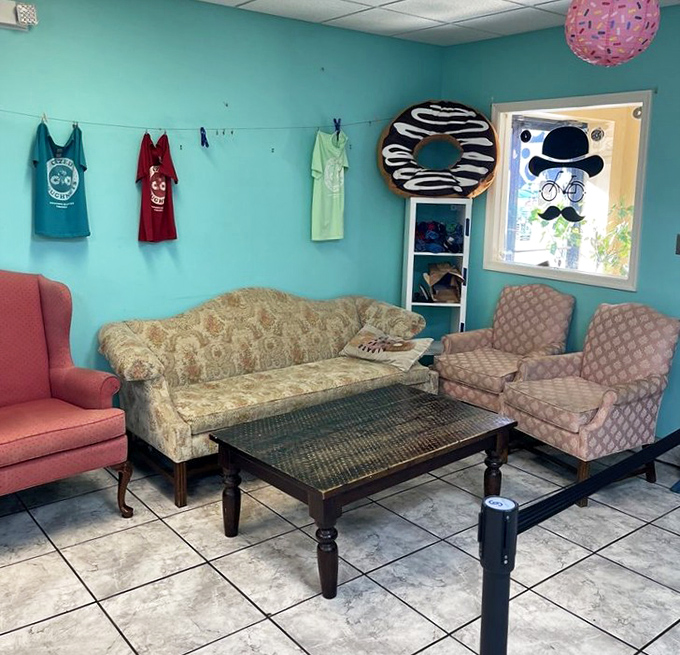 Vintage furniture creates a living room vibe, complete with a giant doughnut watching over you like a sugary guardian angel.