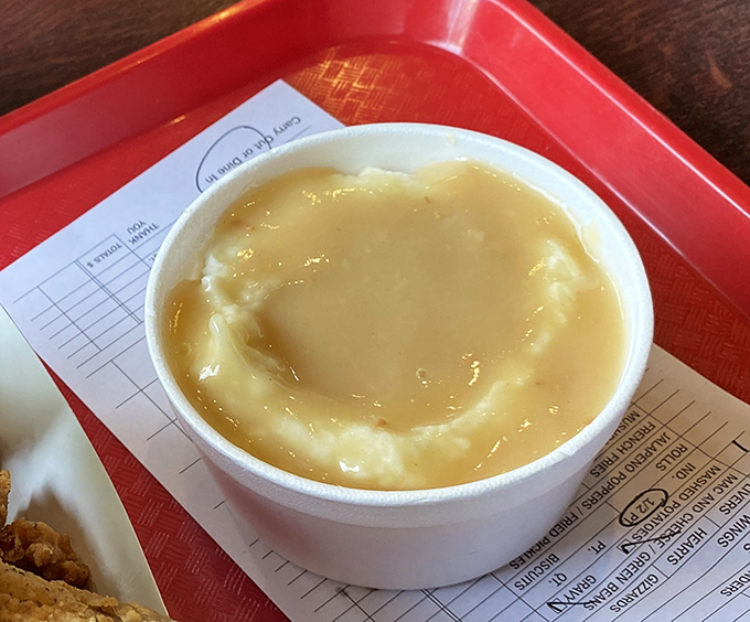 Mashed potatoes swimming in golden gravy—the kind of side dish that threatens to upstage even the magnificent fried chicken.