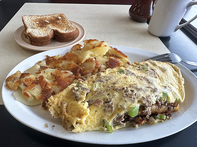 This isn't just an omelet – it's a masterclass in technique, filled with savory ingredients and served alongside potatoes crisped to golden perfection.