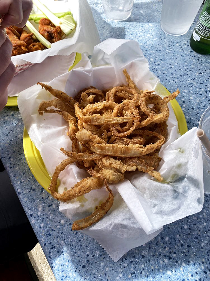 Crispy onion strings piled high like a golden nest &ndash; the perfect side dish or, let's be honest, something to snack on while waiting for more seafood.