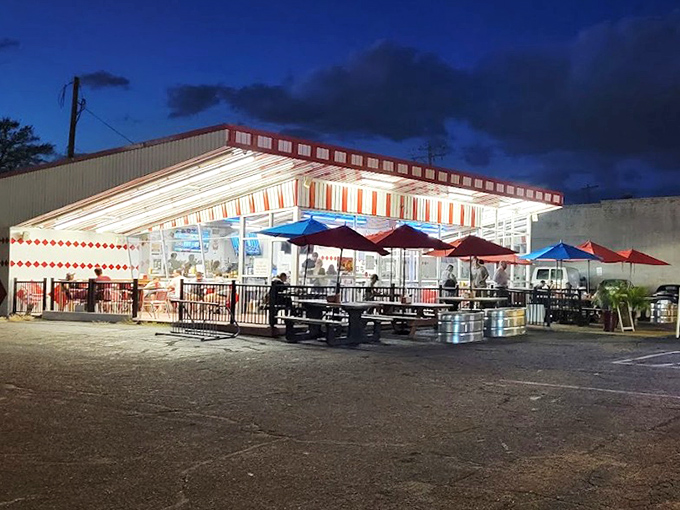 As night falls, Boulevard Burger transforms into a glowing beacon of comfort food. Those red umbrellas stand like sentinels of satisfaction.