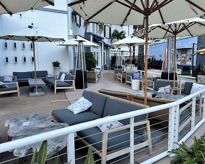 As evening approaches, the outdoor lounge area transforms into a serene retreat where cocktails and conversation flow as freely as the ocean breeze.