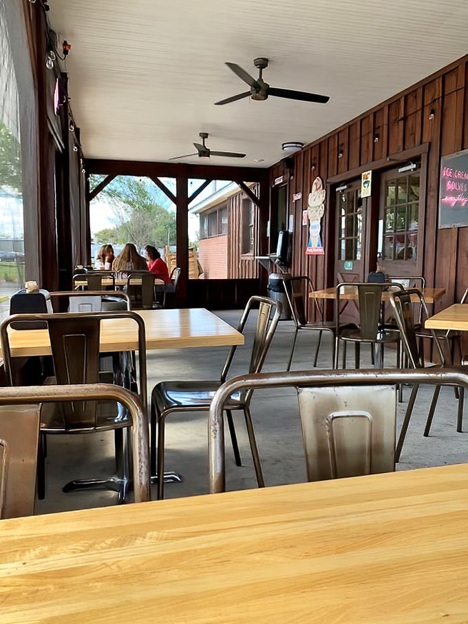 The covered porch offers a more intimate dining experience. Those metal chairs might look industrial, but they've cradled countless happy diners through epic meals.
