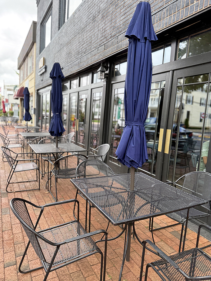 The sidewalk seating area offers a front-row view of downtown Freehold life, with navy umbrellas standing ready to shield your butter chicken from unexpected Jersey showers.