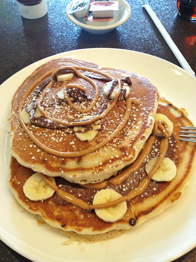Pancakes with attitude. These fluffy discs of joy, drizzled with peanut butter sauce and studded with banana slices, make mornings worth facing.