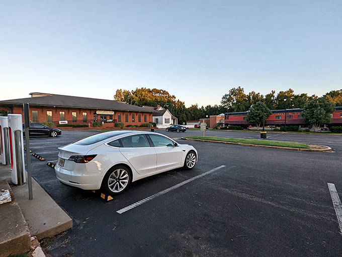 Even the parking area offers glimpses of railroad history, with vintage train cars peeking through the trees like old friends waiting to be rediscovered.