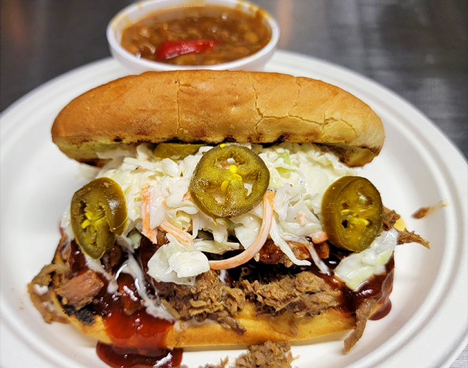 Pulled pork piled high with slaw and jalapeños—a sandwich that demands to be eaten with both hands and plenty of napkins nearby.
