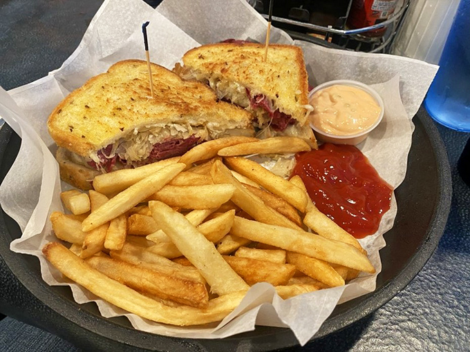 A Reuben sandwich that's dressed and ready for its close-up, with fries that refused to be upstaged.