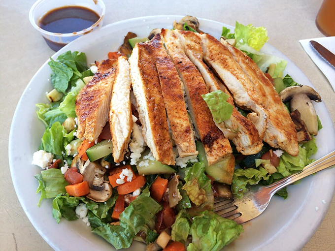 A salad that's trying to make amends for last night's pizza choices, with grilled chicken standing guard over colorful vegetables.