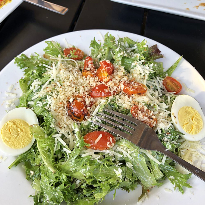 A Caesar salad that actually deserves the name&mdash;fresh greens, proper dressing, and enough parmesan to remind you that vegetables can be exciting.