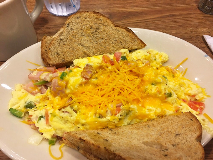 An omelet that's not afraid to show off its fillings. Cheese melts across the top like sunshine, while toast stands by for mopping duties.