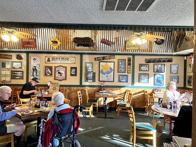 The dining area balances rustic charm with comfortable seating, while corrugated metal and bear silhouettes overhead remind you exactly where you are.