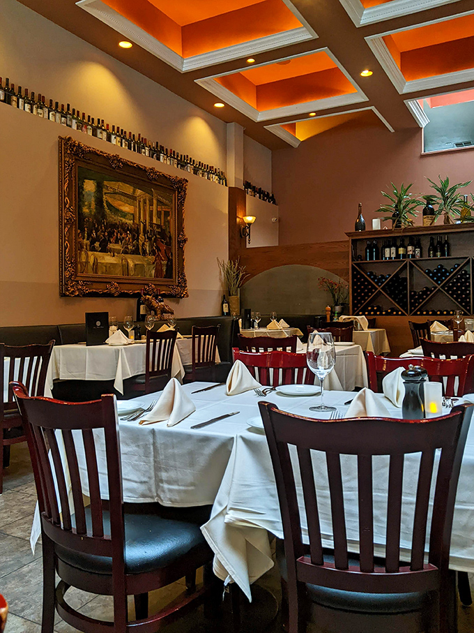 The dining room's coffered ceiling with warm orange insets creates an atmosphere where every table feels like the best seat in the house.
