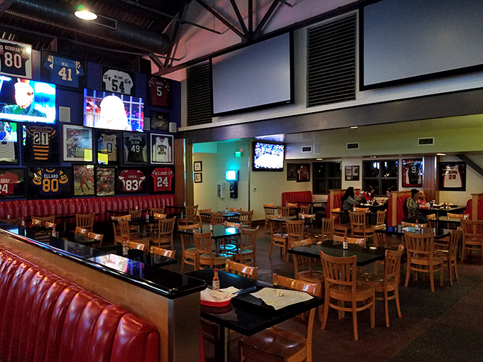 Sports memorabilia adorns walls above red booths, creating an atmosphere where food and fandom merge in a celebration of California casual dining.