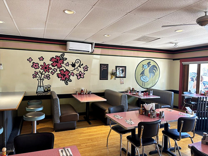 Whimsical wall art adds character to comfortable booths. The rooster mural watches over diners like a proud breakfast guardian.