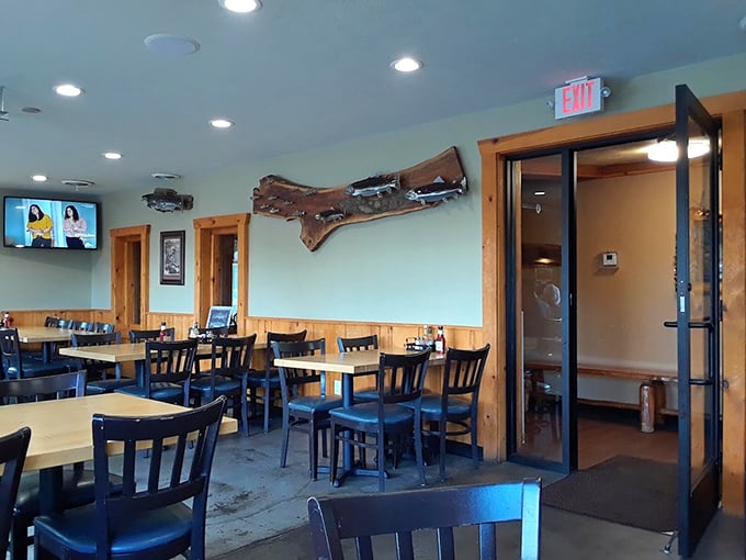 Simple, comfortable seating with a touch of Up North charm, including what appears to be the Upper Peninsula's wooden silhouette watching over diners.