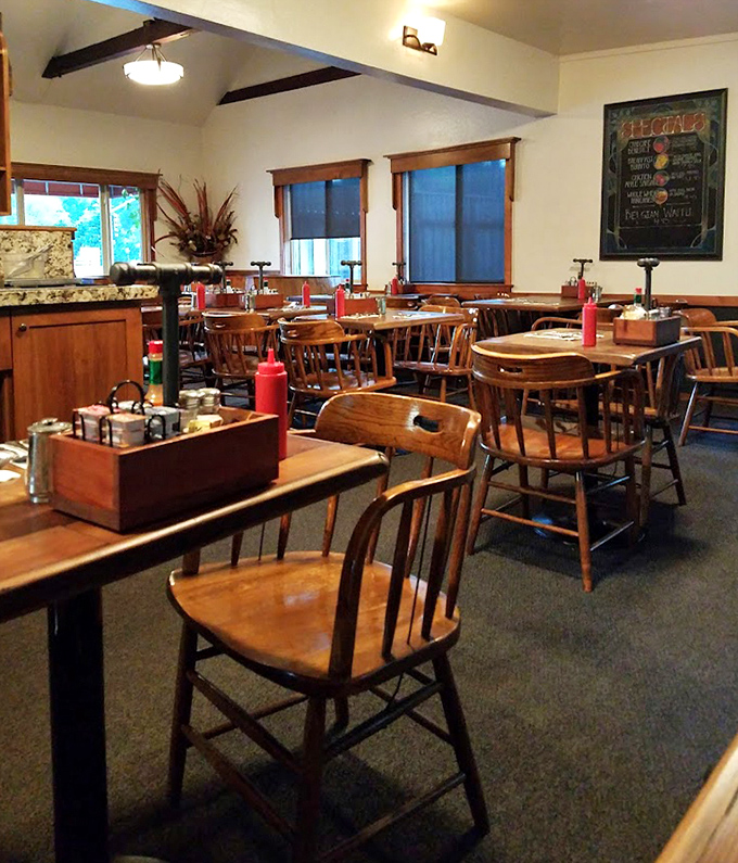 Classic wooden chairs and tables arranged for comfort, not Instagram. A dining room that invites you to stay for "just one more coffee."