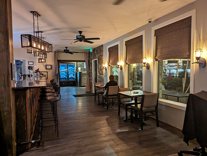 The transitional space between bar and dining room offers intimate corners for quiet conversations and celebratory toasts.