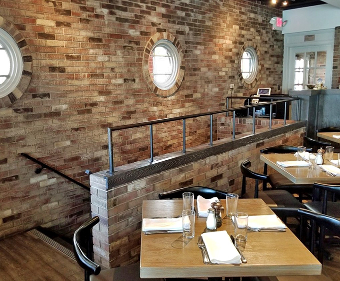 Circular windows punctuate brick walls, creating a dining space that feels both architecturally interesting and comfortably familiar.