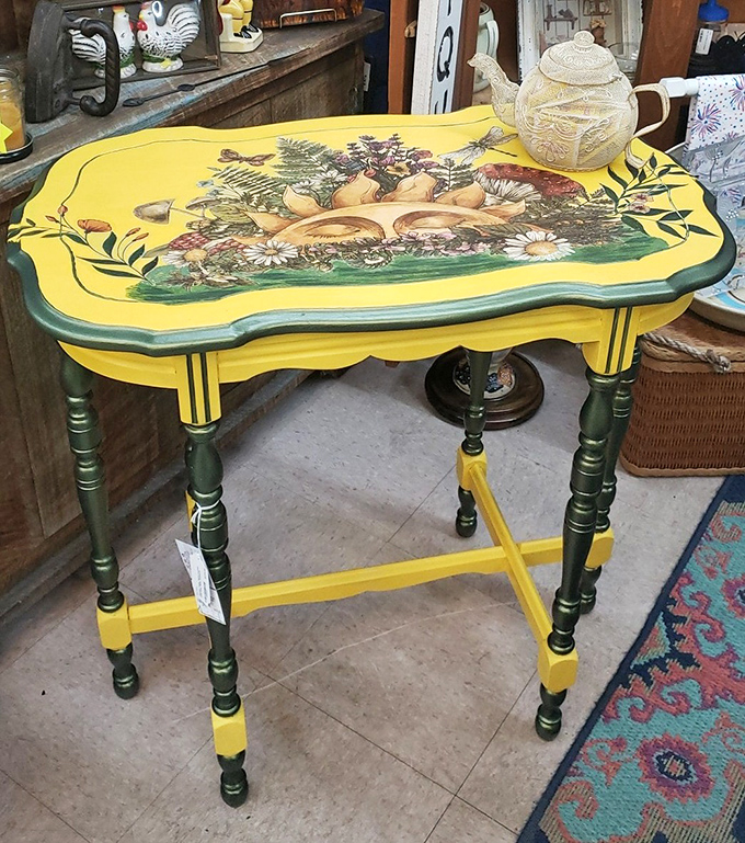 A whimsically painted yellow table that somehow makes perfect sense, even though you never knew you needed a furniture piece with mushroom art.