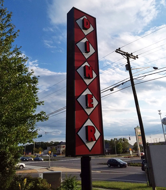The vertical signage stands like a beacon of hope for hungry travelers. Those diamond-shaped letters spell relief for empty stomachs.