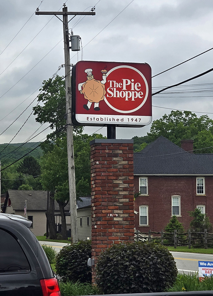 The sign says it all—a cheerful pie mascot welcoming hungry travelers since 1947. Some landmarks have historical significance; this one has delicious significance.