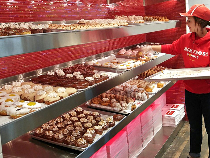 The red-shirted donut whisperers, carefully arranging their creations with the precision of museum curators.