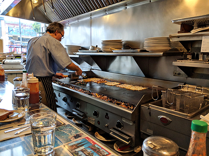 Watching a griddle master at work is like seeing a conductor lead a symphony of sizzles, spatula flips, and perfectly timed plate slides.