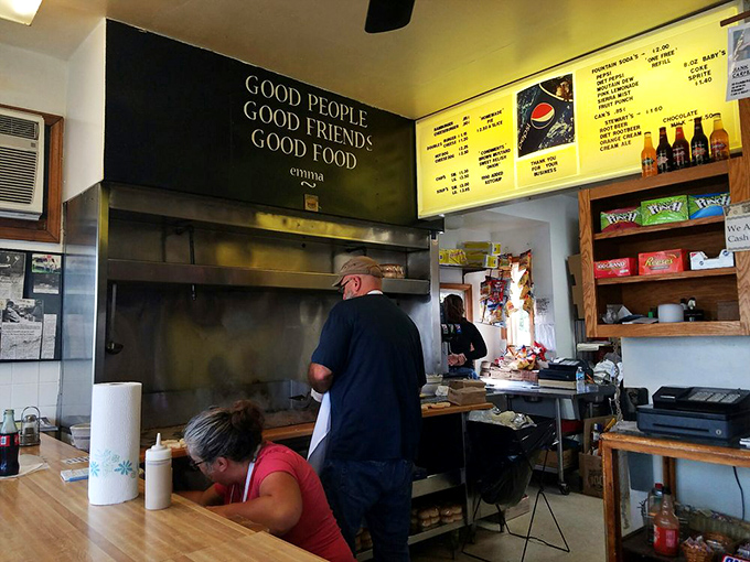 Beneath a sign that sums up the Crabill's philosophy, staff members orchestrate the timeless dance of grill-to-bun perfection.