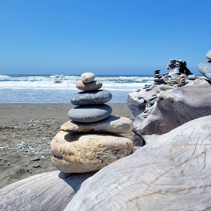 Someone's been playing nature's version of Jenga, stacking stones into meditative sculptures against the rhythmic soundtrack of crashing waves.