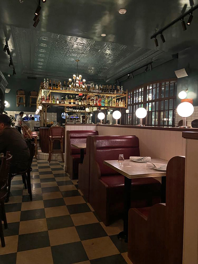 Red leather booths invite intimate conversations while the pressed tin ceiling adds vintage charm. The perfect backdrop for both first dates and fiftieth anniversaries.