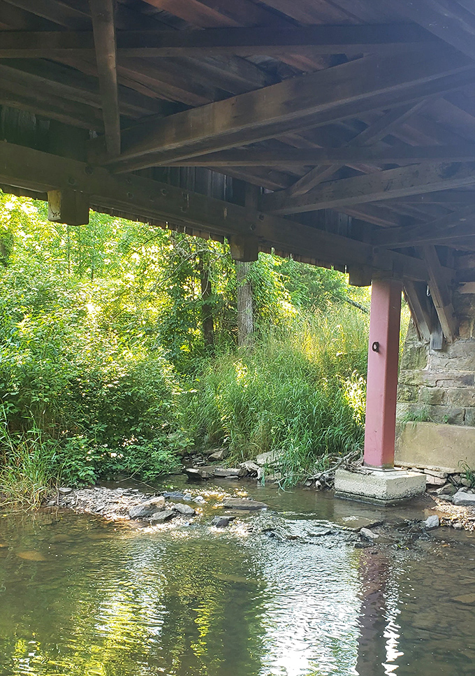 Peek beneath the bridge and discover the gentle stream it spans, sunlight dancing on water that's flowed here since long before 1886.