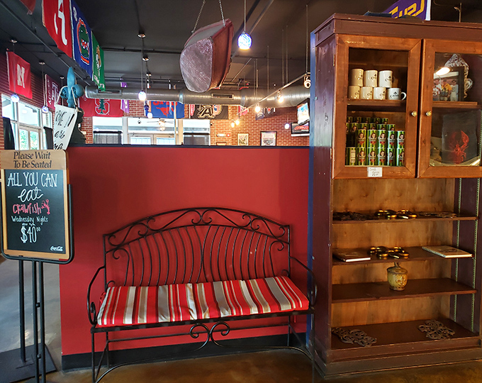The waiting area's red bench isn't just seating; it's where anticipation builds and the aroma of Cajun spices teases what's to come.