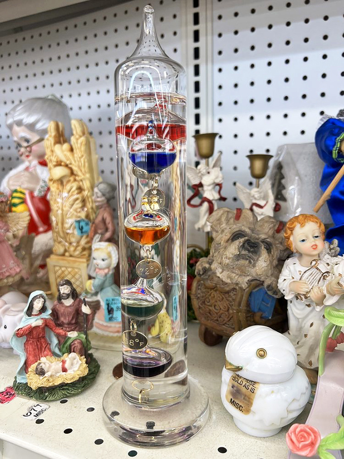 Religious figurines surround a Galileo thermometer in perfect thrift store harmony. Science and faith together at last&mdash;for just a few dollars!
