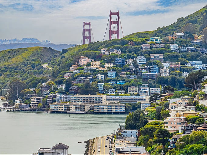 Sausalito's hillside homes cascade toward Richardson Bay, where Golden Gate Bridge views and floating houseboats create waterfront living dreams.