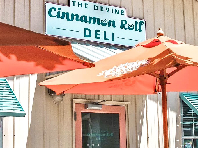 The Devine Cinnamon Roll Deli's charming exterior and patio umbrellas invite you to linger over sweet treats and coffee.