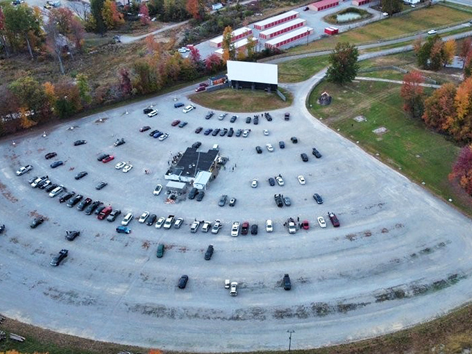 The perfect symmetry of cars arranged like faithful disciples before their silver screen altar. Drive-in geometry is an art form.