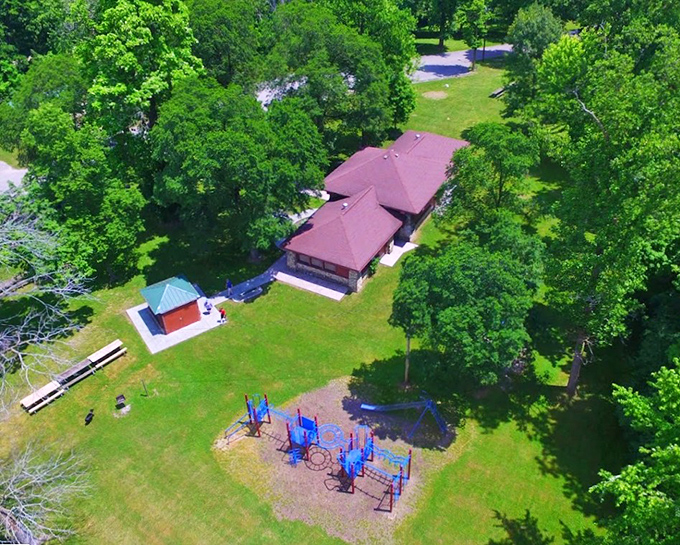 An aerial view showcases Highland Park's perfect blend of natural beauty and recreational spaces, where families create memories between visits to giant stumps and stuffed steers.