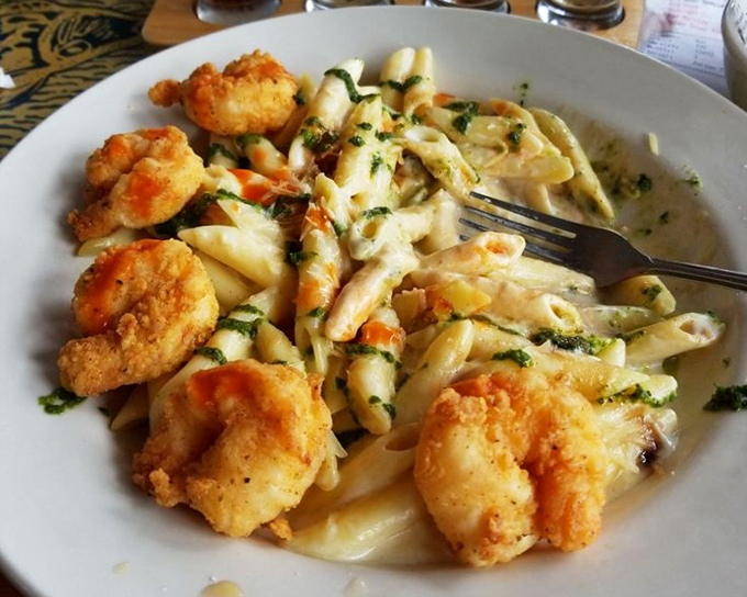 Pasta that doesn't apologize for its richness – golden fried shrimp lounging on creamy alfredo like they're at a seafood spa.