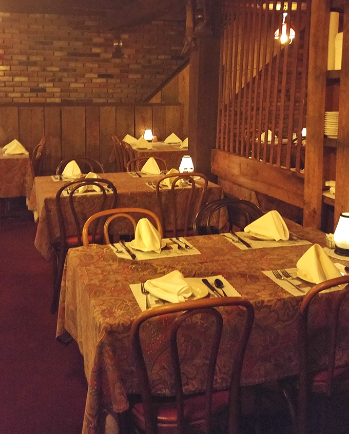 White tablecloths and carefully folded napkins signal that this rustic setting takes its food seriously &ndash; country charm meets culinary precision.
