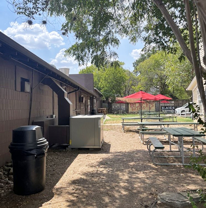 Outdoor seating where the Texas breeze carries smoke signals that whisper, "Yes, you can absolutely take a post-brisket nap here."