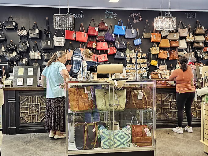 The handbag wall is a rainbow of leather possibilities, where Coach, Dooney & Bourke, and Michael Kors mingle democratically.