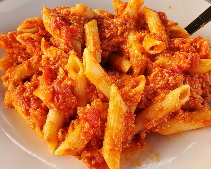 Penne pasta swimming in rich tomato sauce—the kind of comfort food that makes you want to hug whoever made it.